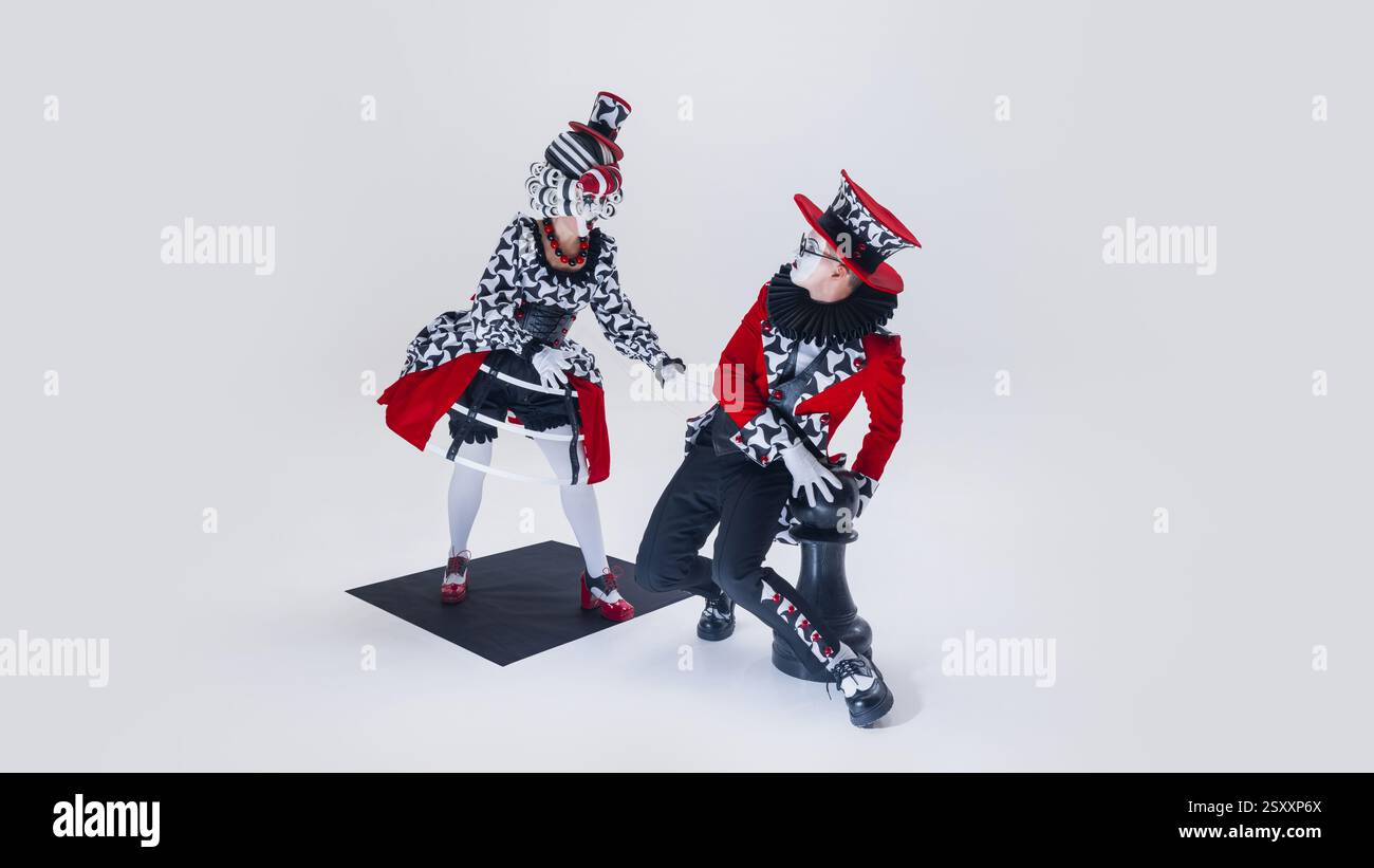 Circus duo in bold theatrical costumes, exchanging dramatic gestures ...