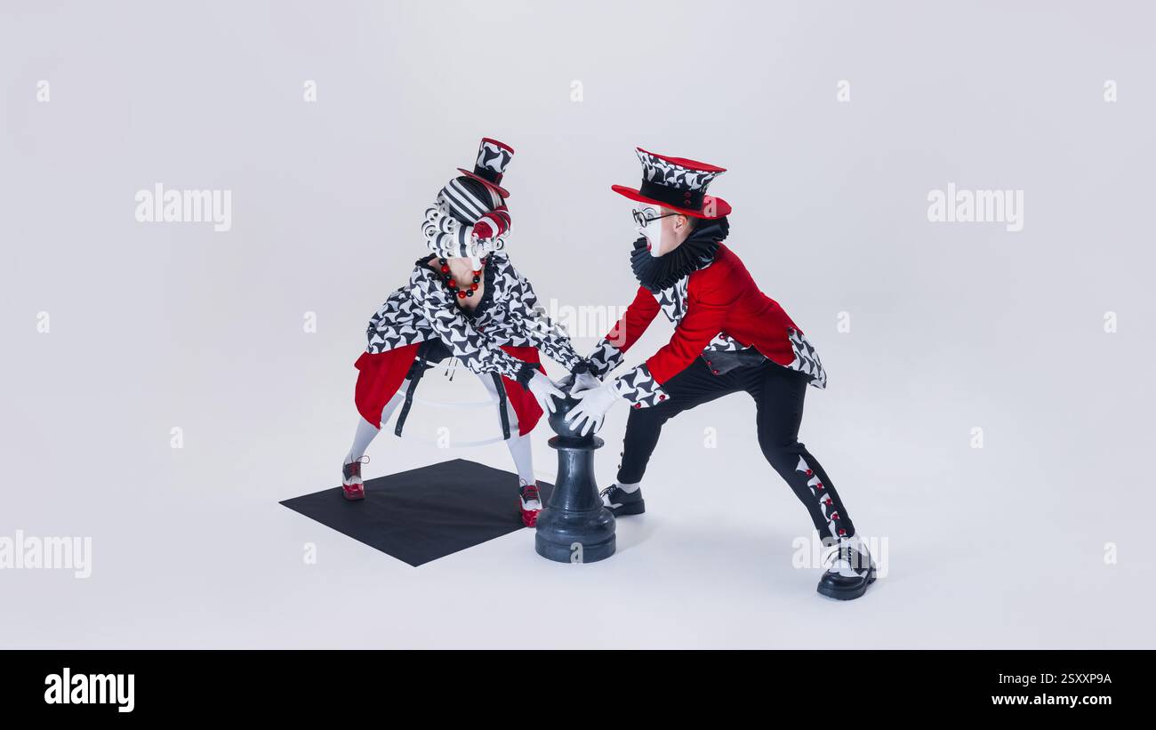Circus performers dramatically gripping oversized chess piece ...