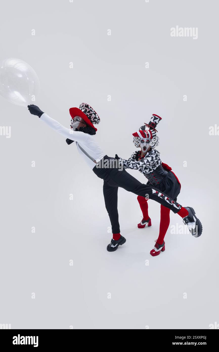 Mime artist stretching dramatically towards floating bubble as animated ...