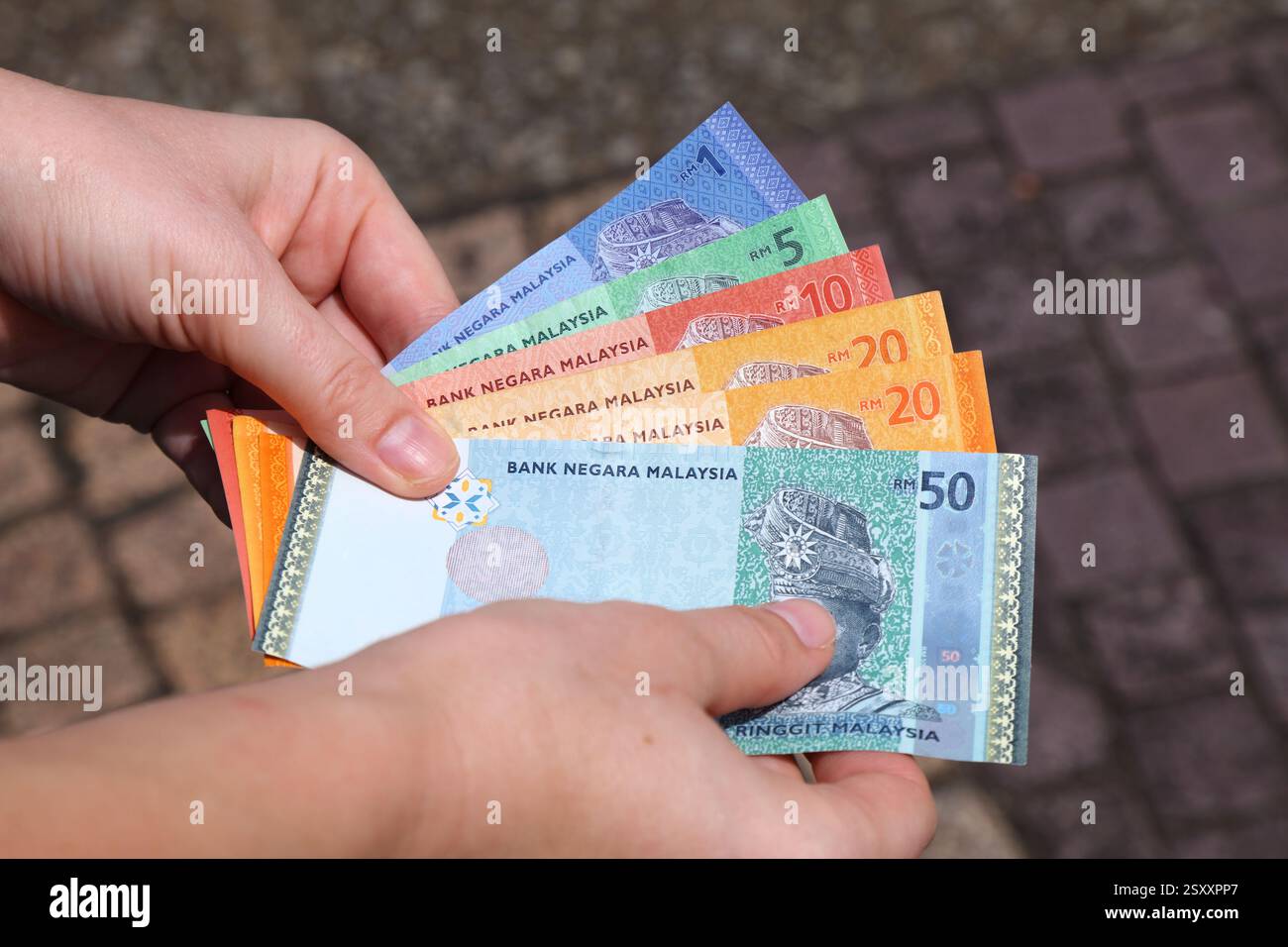 Hand holding Malaysian ringgit paper money. 1, 5, 10, 20 and 50 ringgit ...