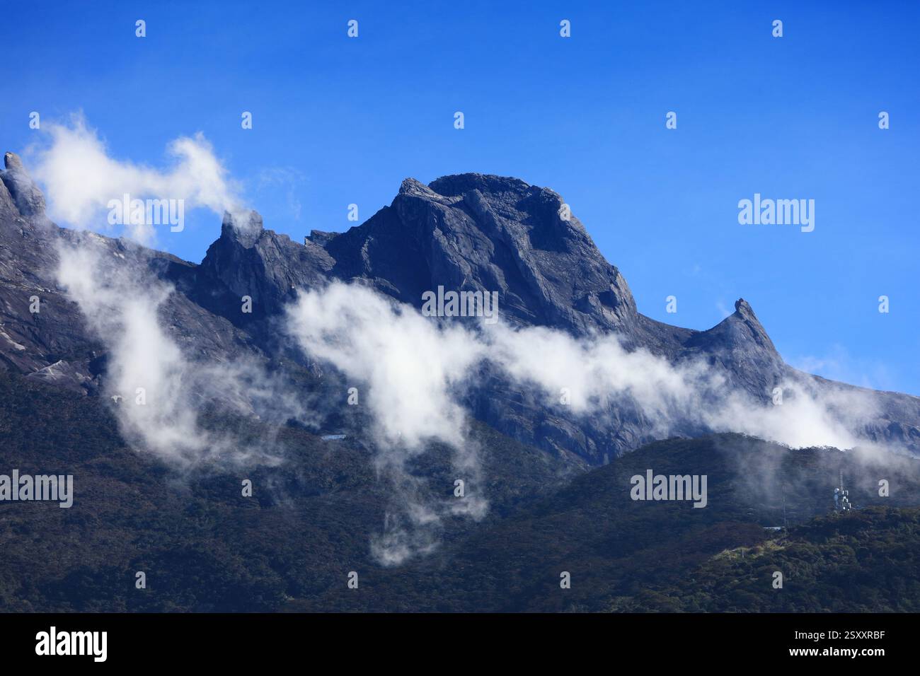 Mount Kinabalu on a sunny day. King Edward's Peak surrounded by clouds ...