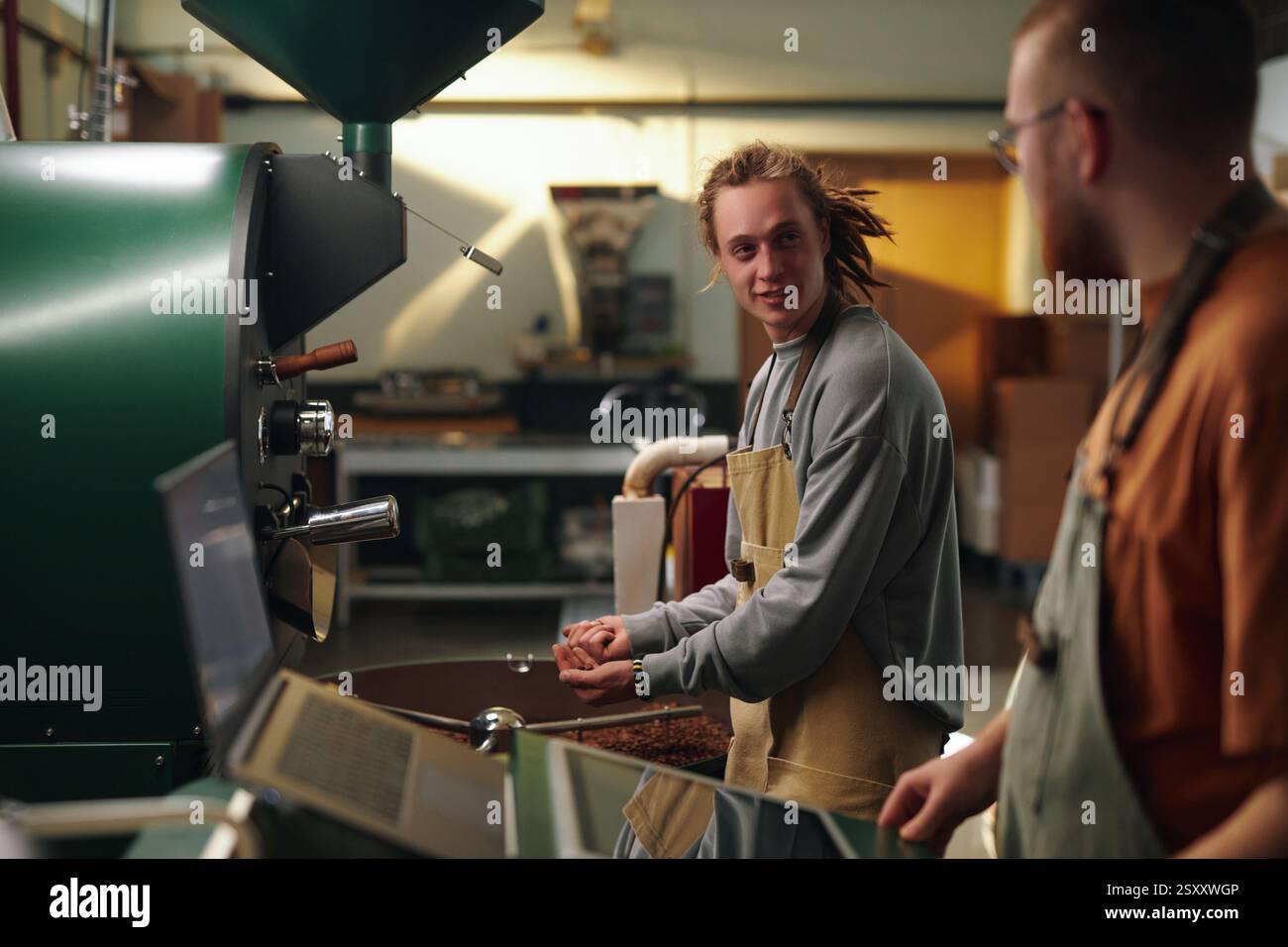 Smiling Caucasian male worker chatting with his colleague while they ...
