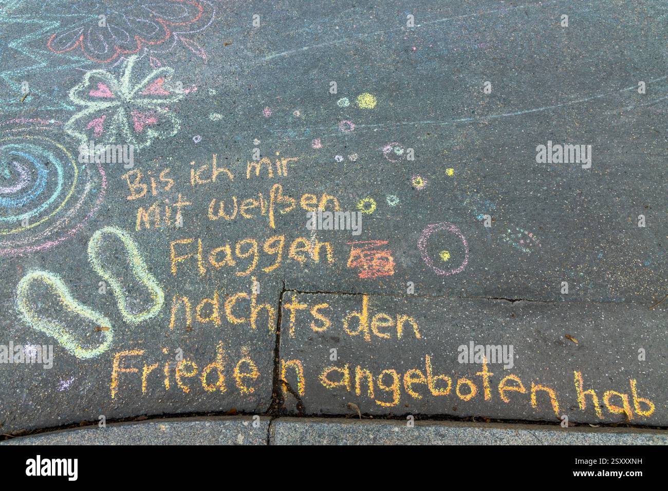 Words in German mean Until I will wave my white flag. Vibrant crayon drawings cover the asphalt ...