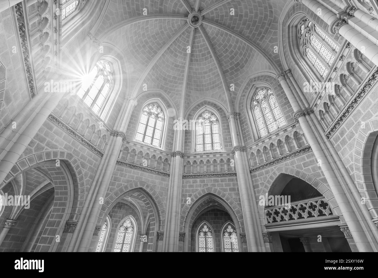 The interior features stunning stone architecture with intricate arches and large stained glass ...