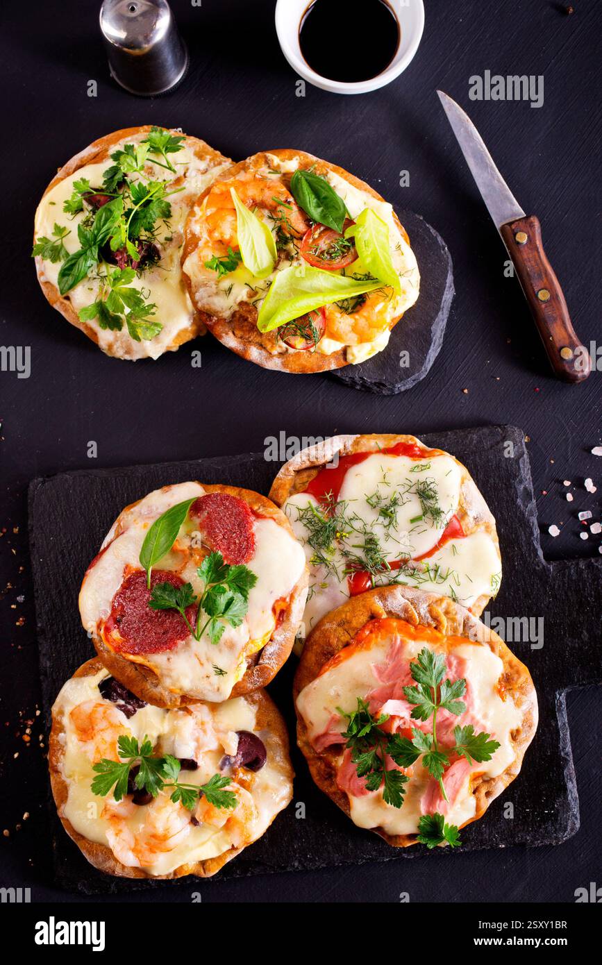 Mini pizzas - pizzette - topped with cheese and tomato plus Italian ham ...