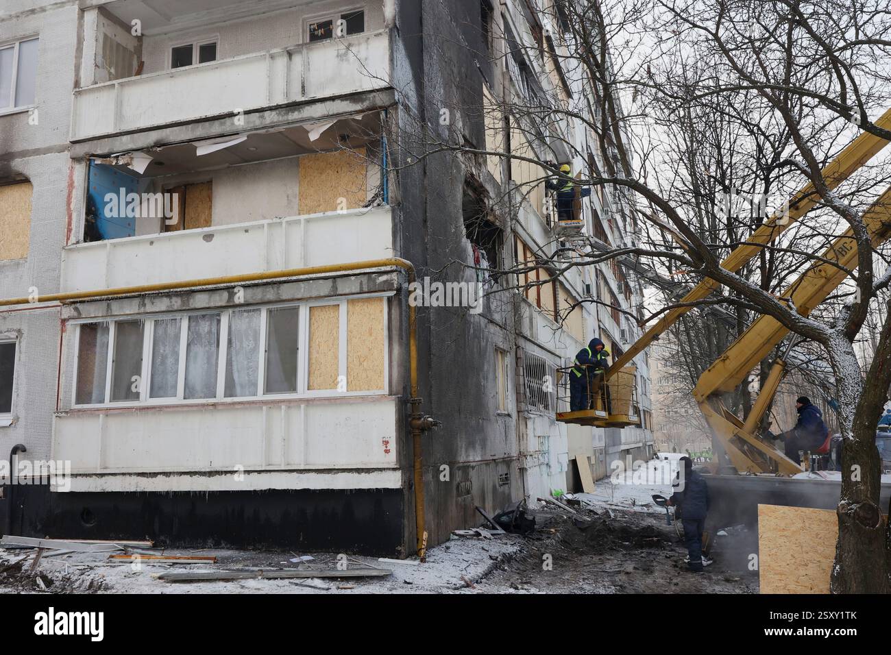 Municipal workers use an aerial work platform to seal windows in an ...