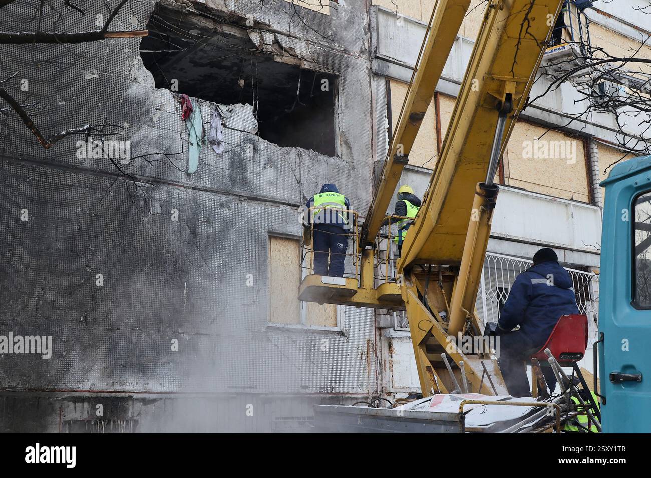Municipal workers use an aerial work platform to seal windows in an ...
