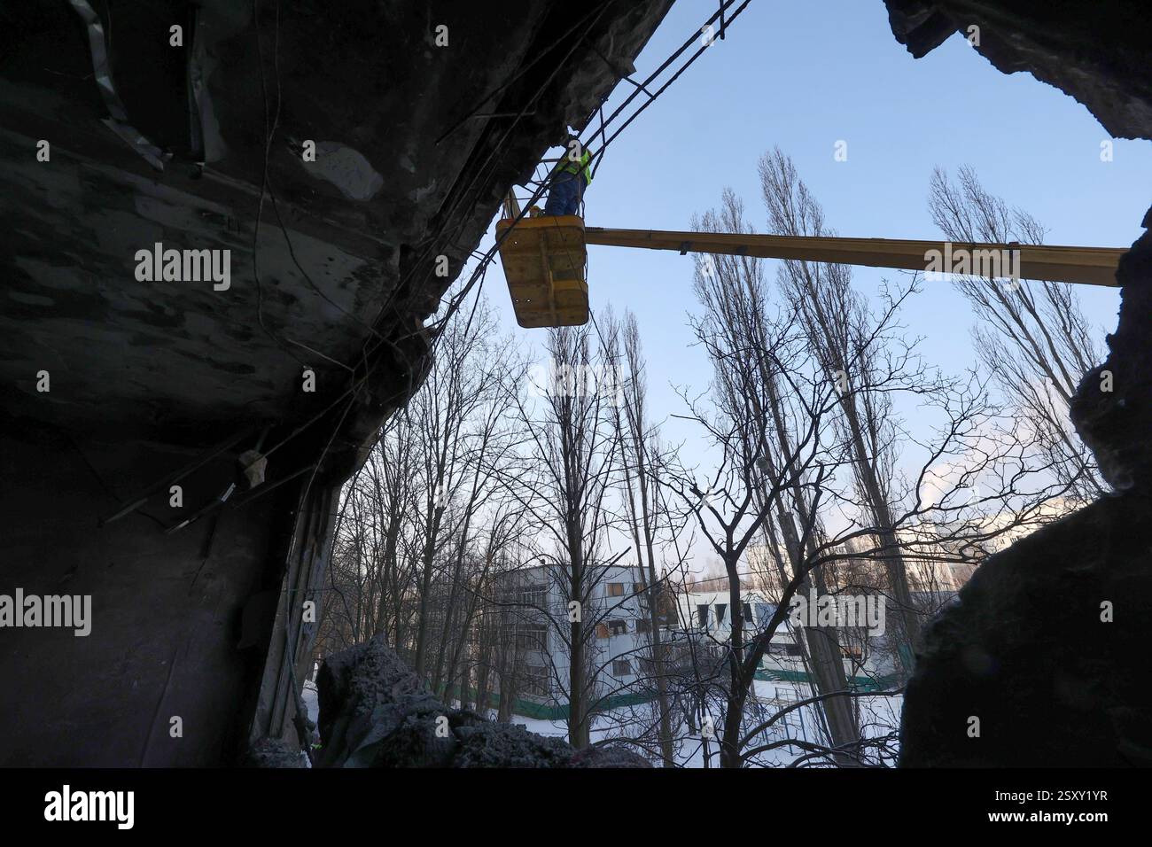 A municipal worker uses an aerial work platform at a building damaged ...