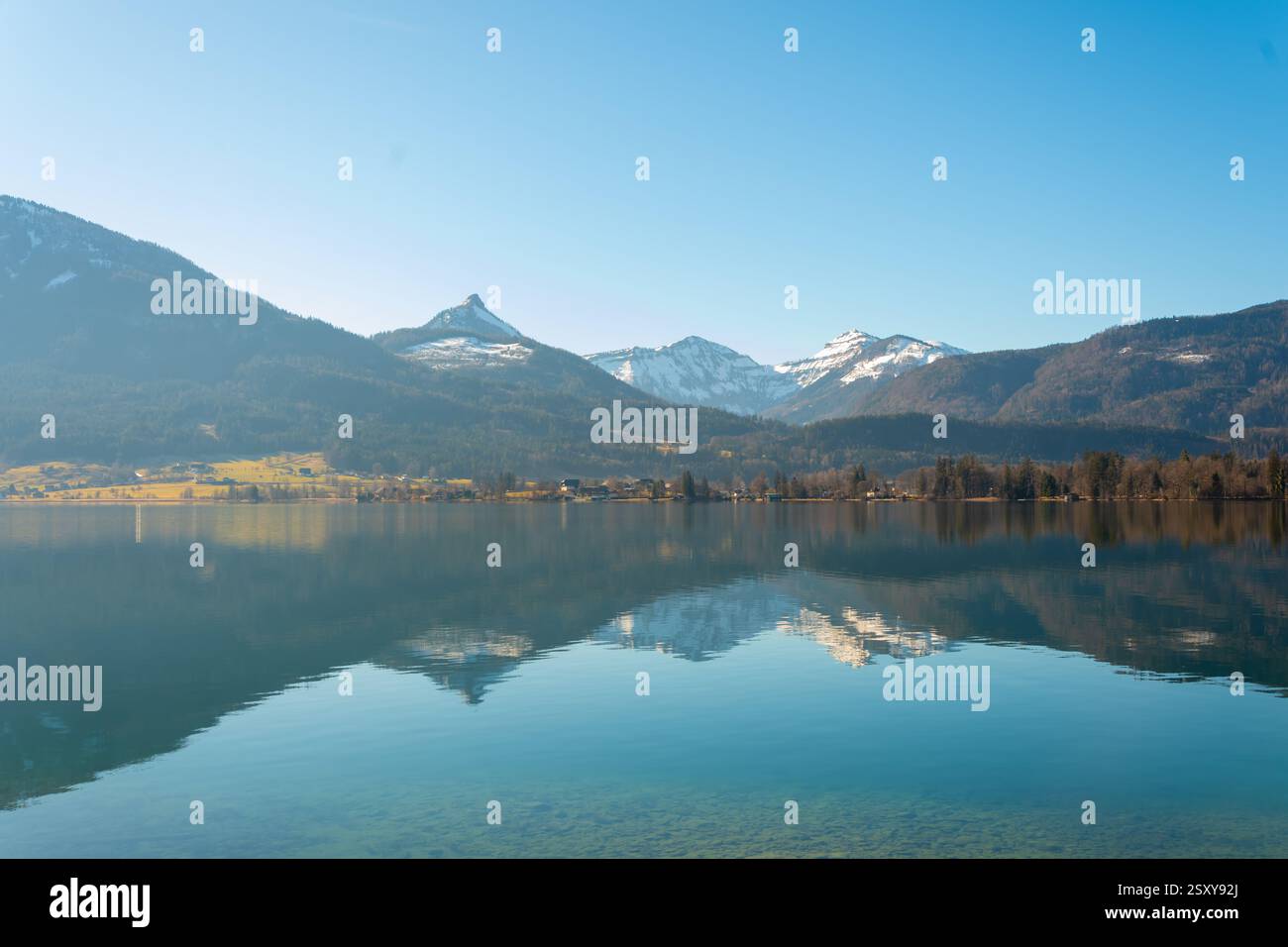 The tranquil Wolfgangsee Lake with its crystal clear water reflects the ...