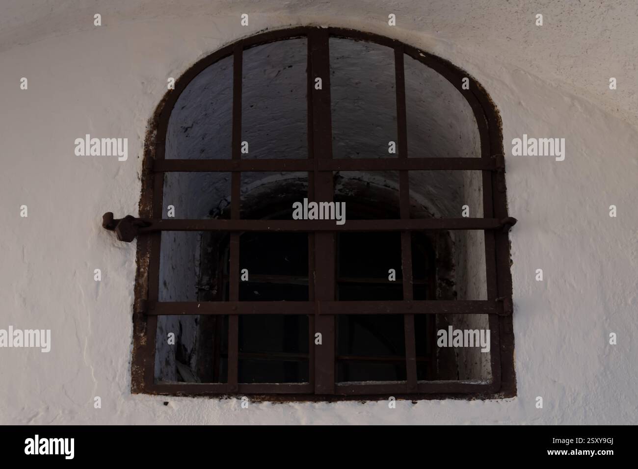 Arched window with bars on yellow antique wall Stock Photo - Alamy