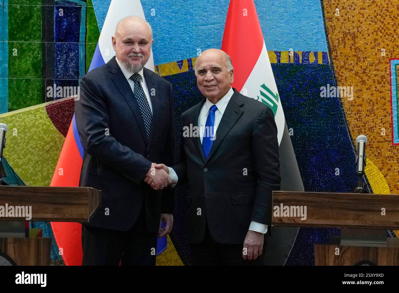 Iraqi Foreign Minister Fuad Hussein, right, shakes hands with visiting ...