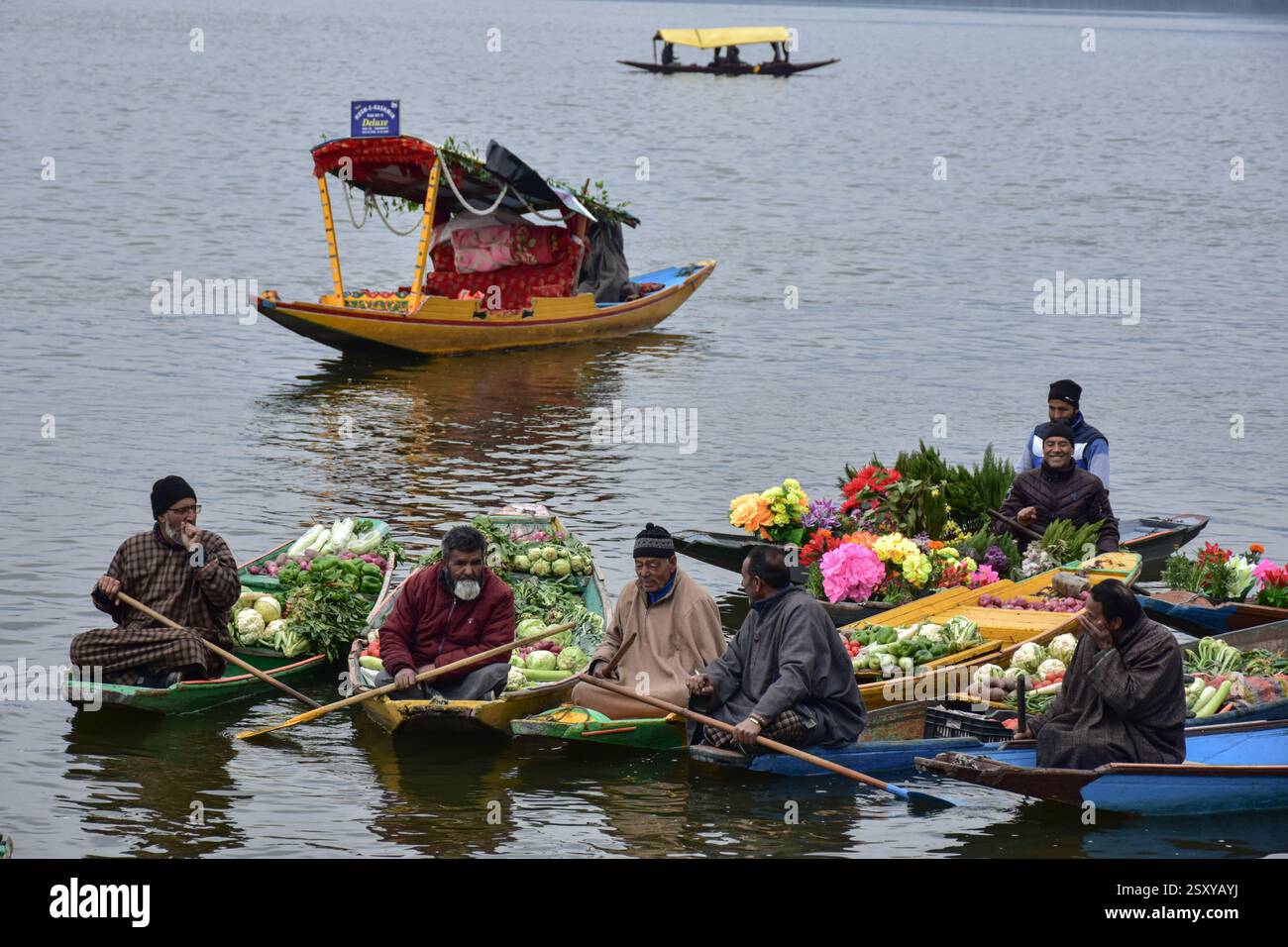 Kashmiri boatmen row their boats laden with vegetables and flowers as ...