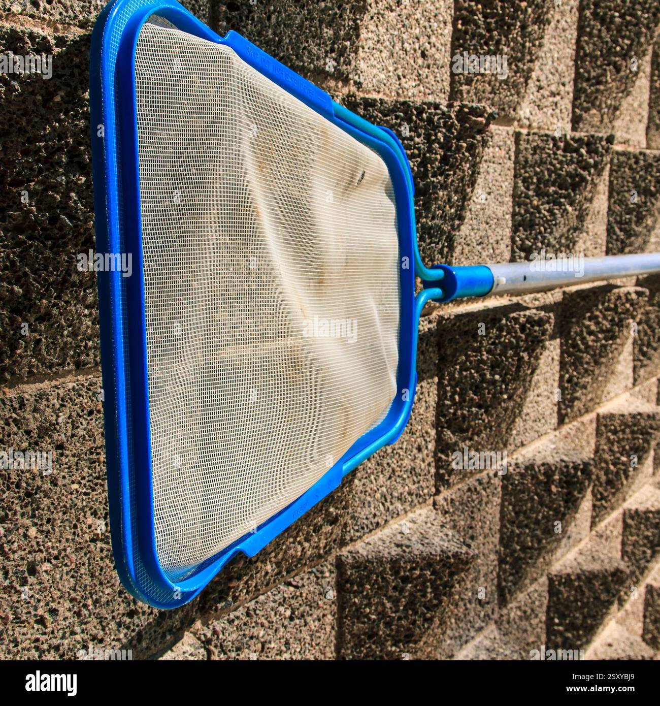 Blue and white net is hanging on a wall. The net is made of a mesh ...