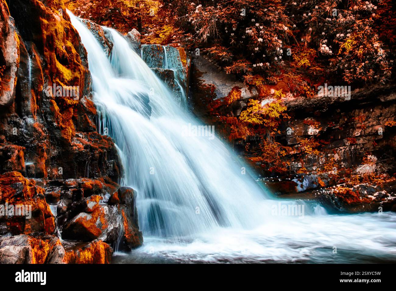 Waterfall with a stream of water flowing down it. The water is clear ...