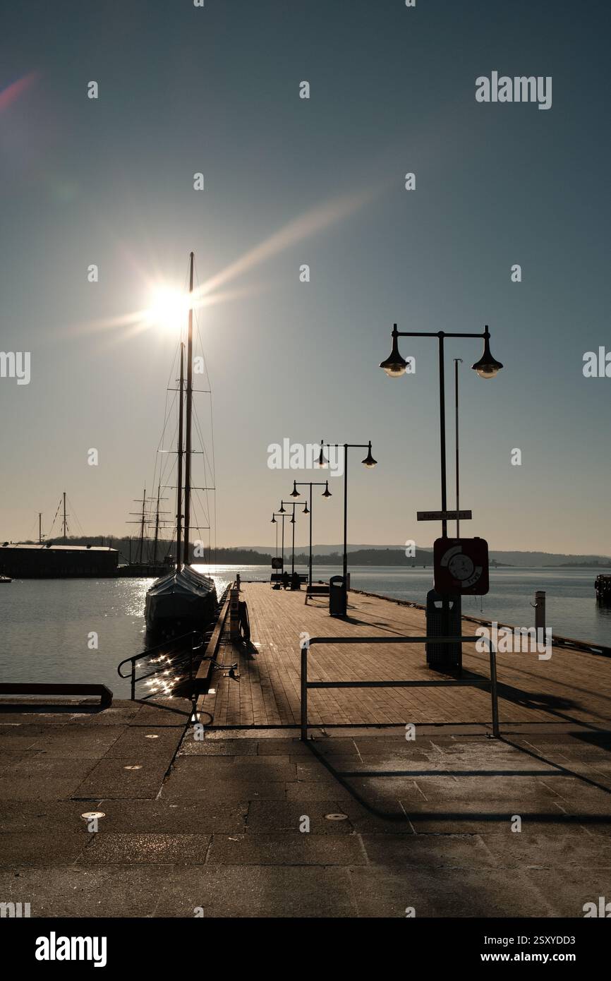 A serene dockside landscape featuring boats under the bright sun ...