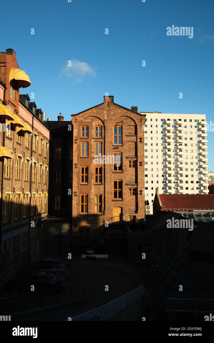 A historic brick factory building juxtaposed with modern architecture ...