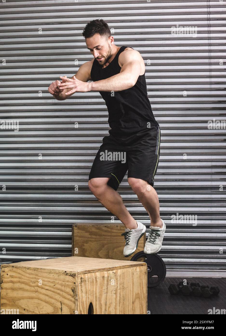 Man performing box jump exercise in gym, focusing on strength and ...