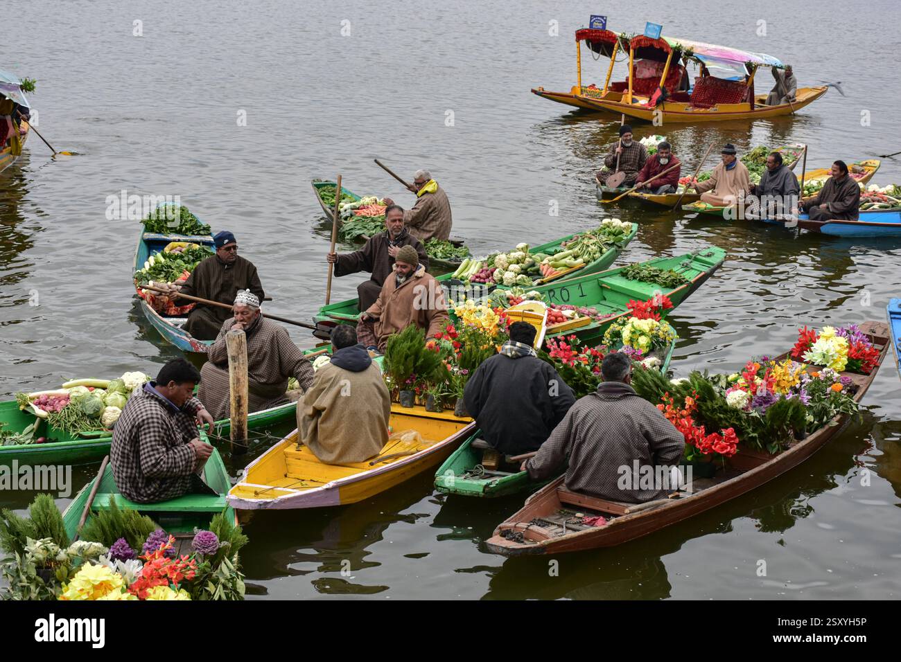 Kashmiri boatmen row their boats laden with vegetables and flowers as ...