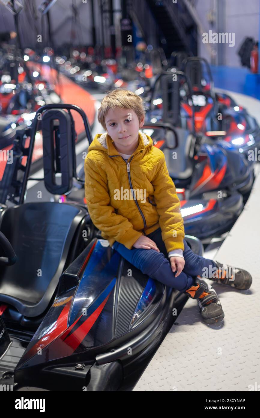 Child, driving go cart car in an indoor race track, enjoying sport ...