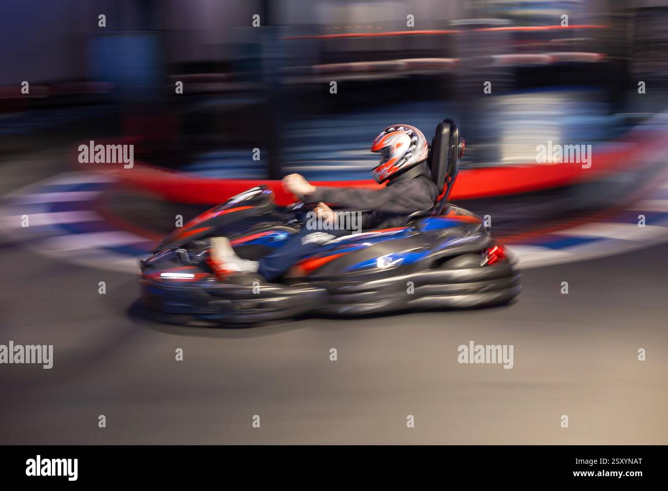 Child, driving go cart car in an indoor race track, enjoying sport ...