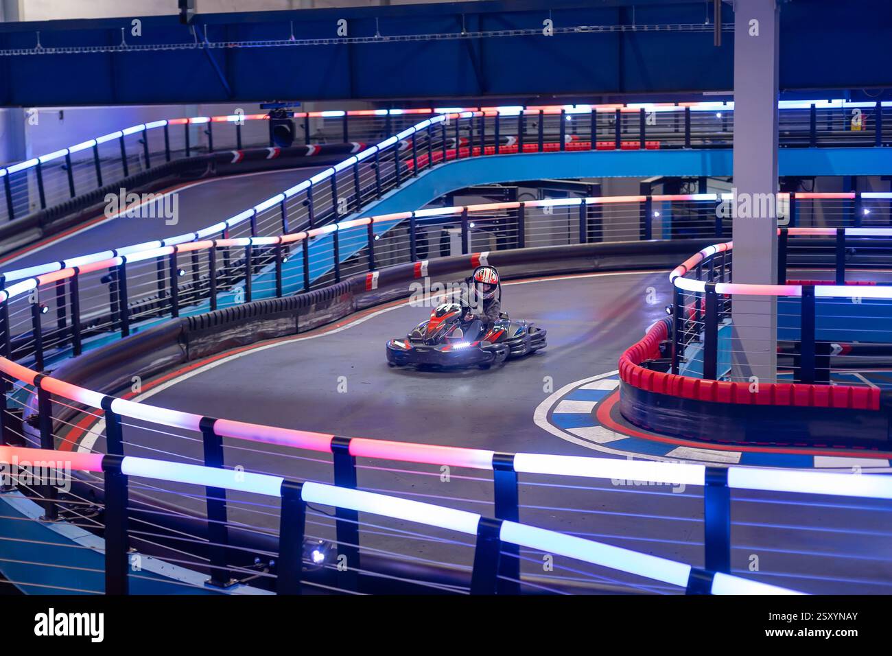 Child, driving go cart car in an indoor race track, enjoying sport ...