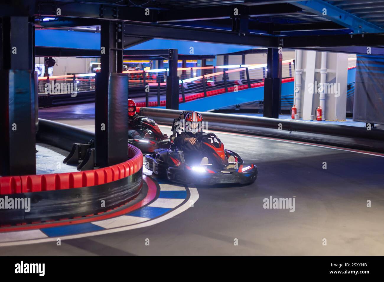 Child, driving go cart car in an indoor race track, enjoying sport ...