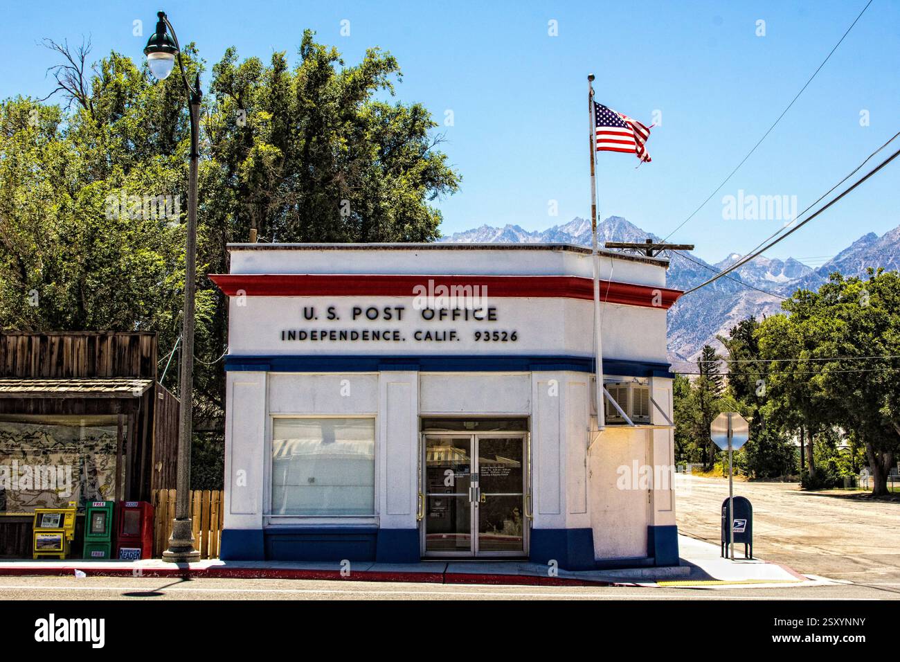Post office building with a flag on top. The building is white and red ...