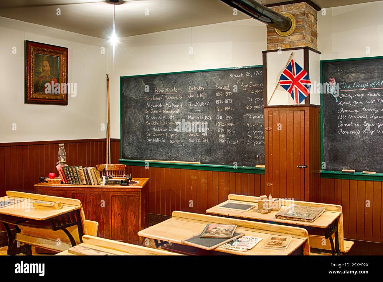 Classroom with a blackboard and a flag on the wall. There are desks ...