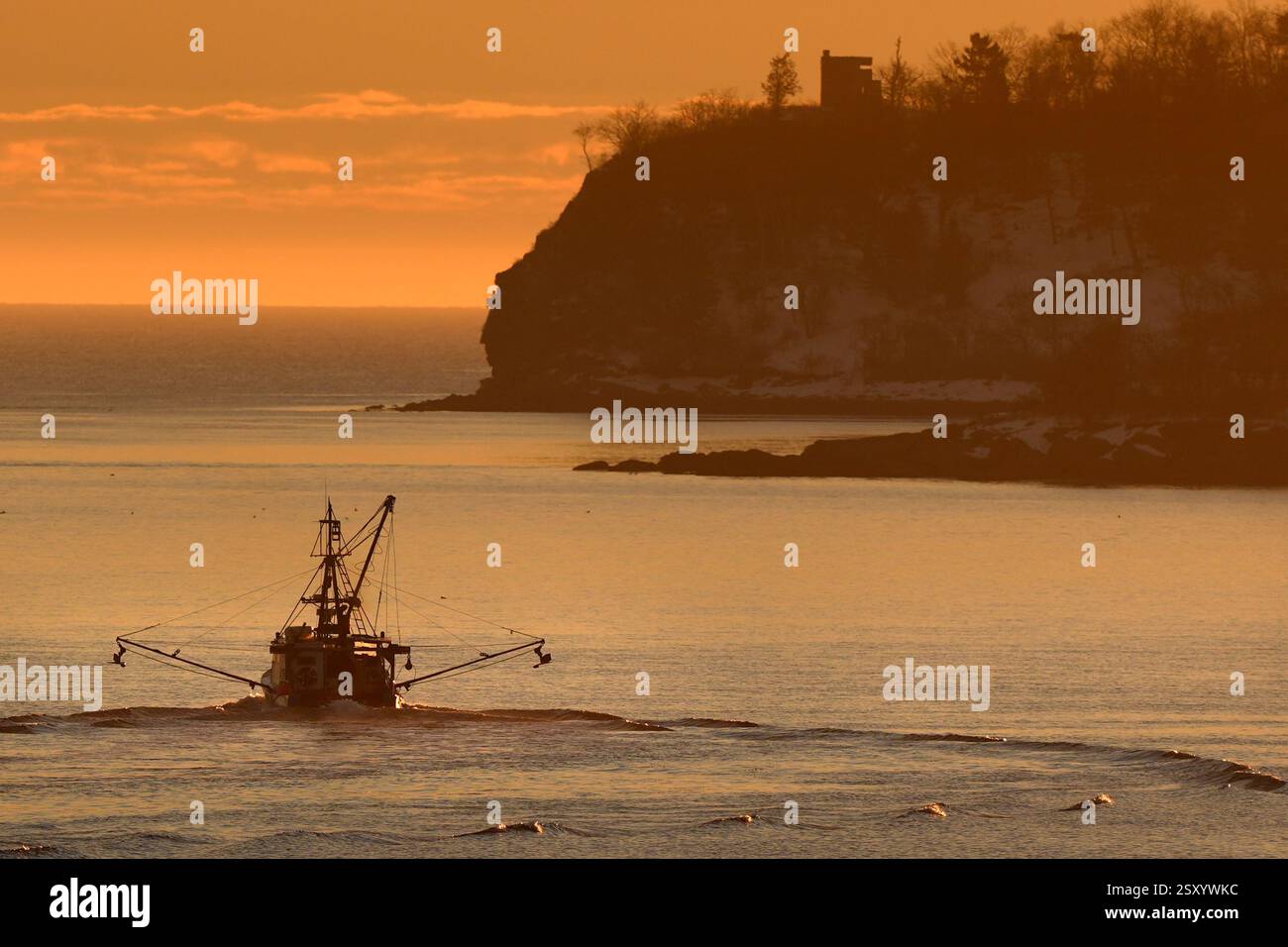 A commercial fishing trawler motors by Cushing Island on its way out to ...