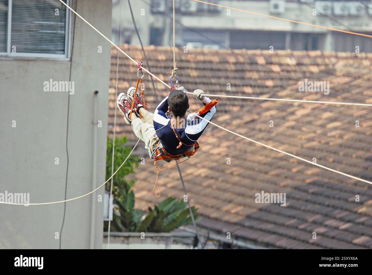 Man crossing between two buildings on rope, Bombay, Mumbai, Maharashtra ...
