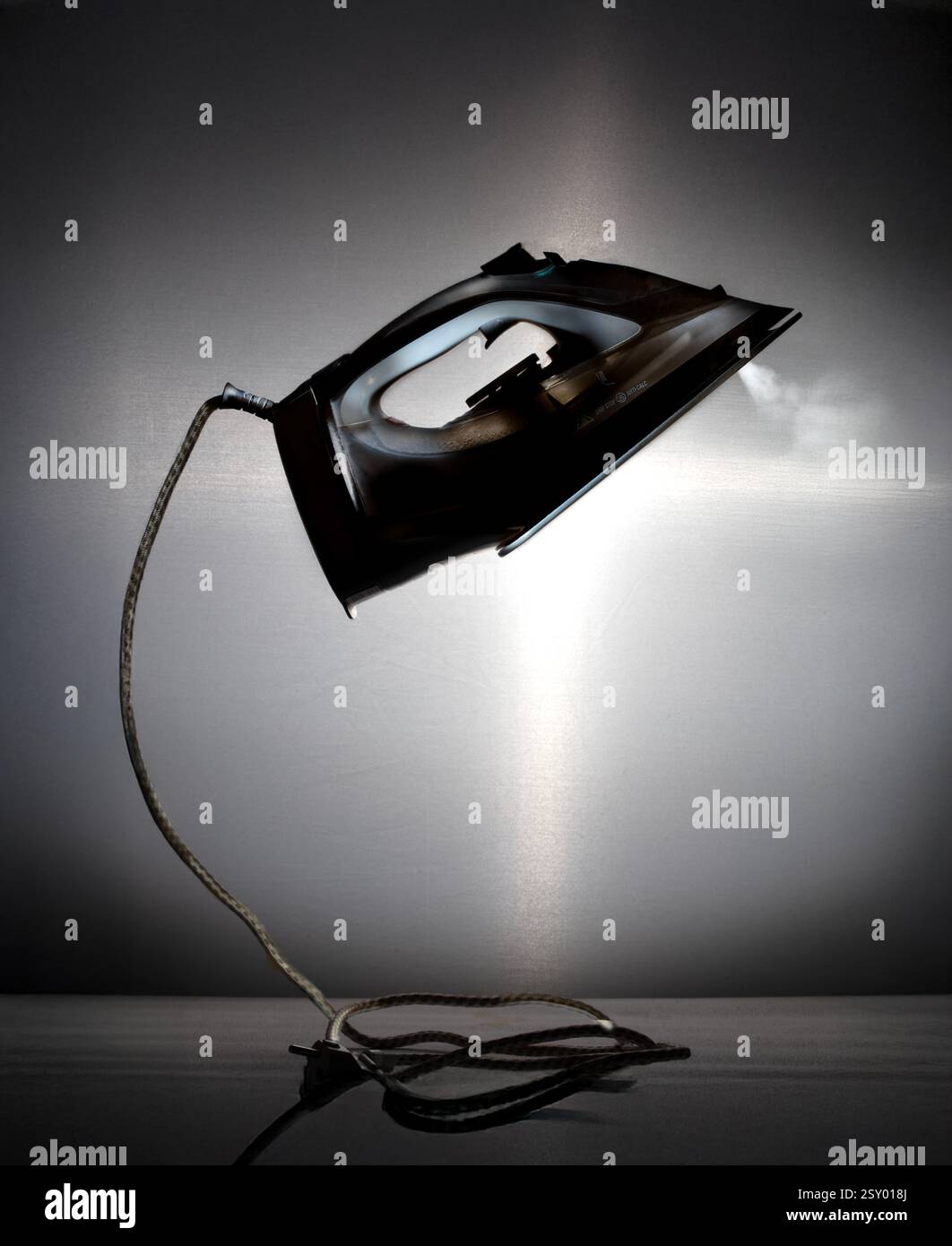 A conceptual photograph featuring a vintage steam iron seemingly ...