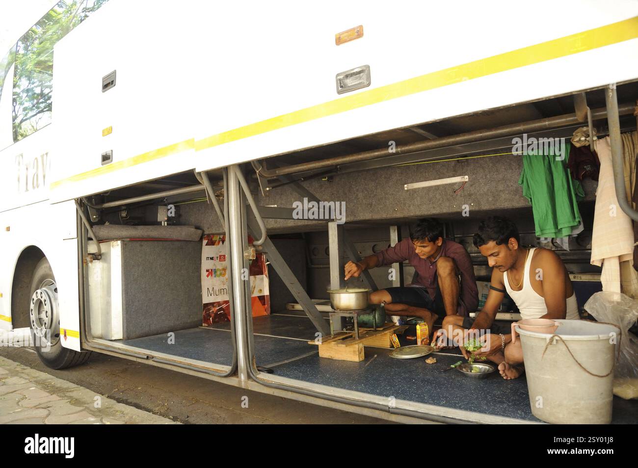 Men cooking in luggage compartment of tourist bus, mumbai, maharashtra ...