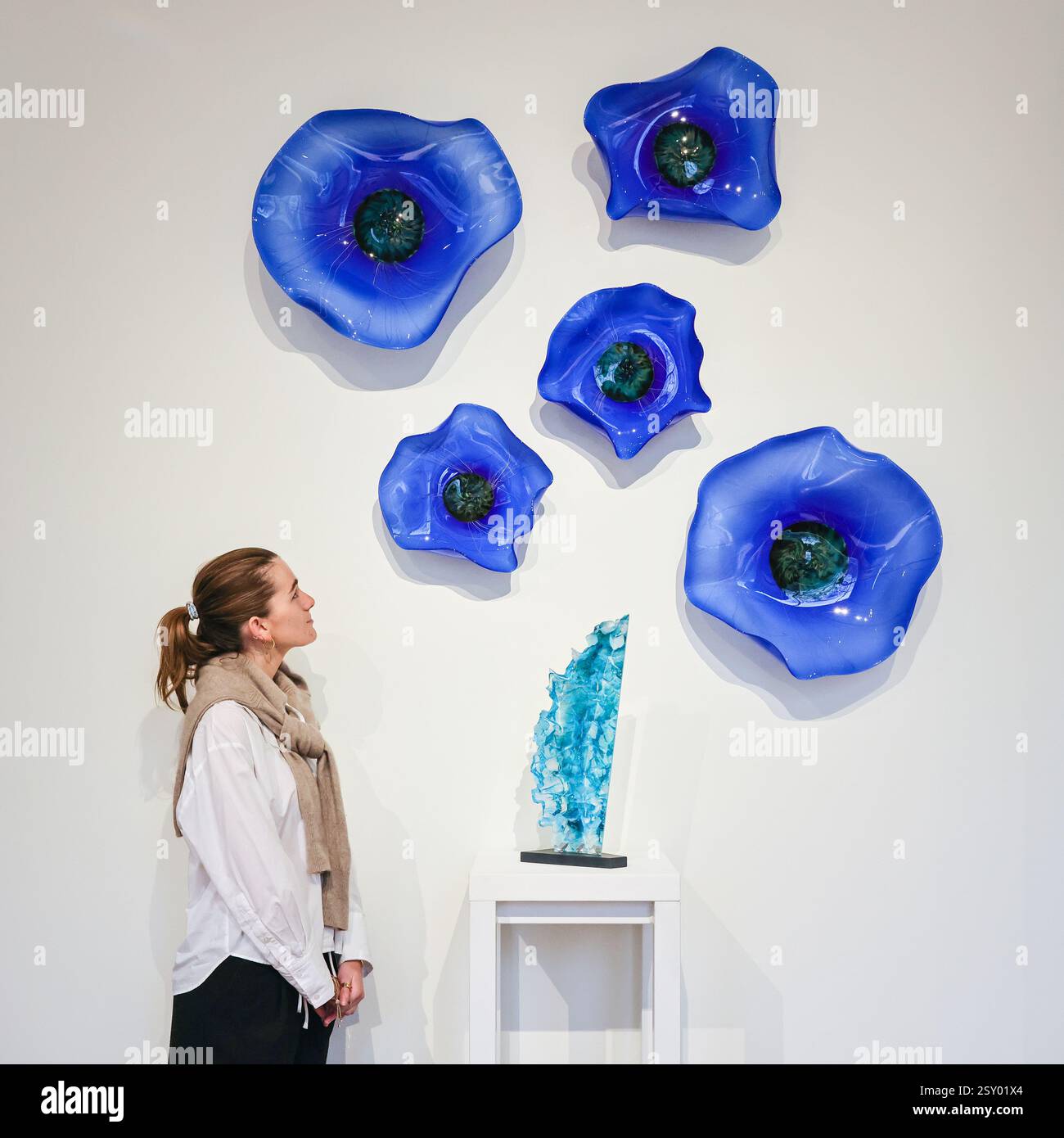 London, UK. 26th Feb, 2025. Staff pose with 'Meconopsis' platters by ...