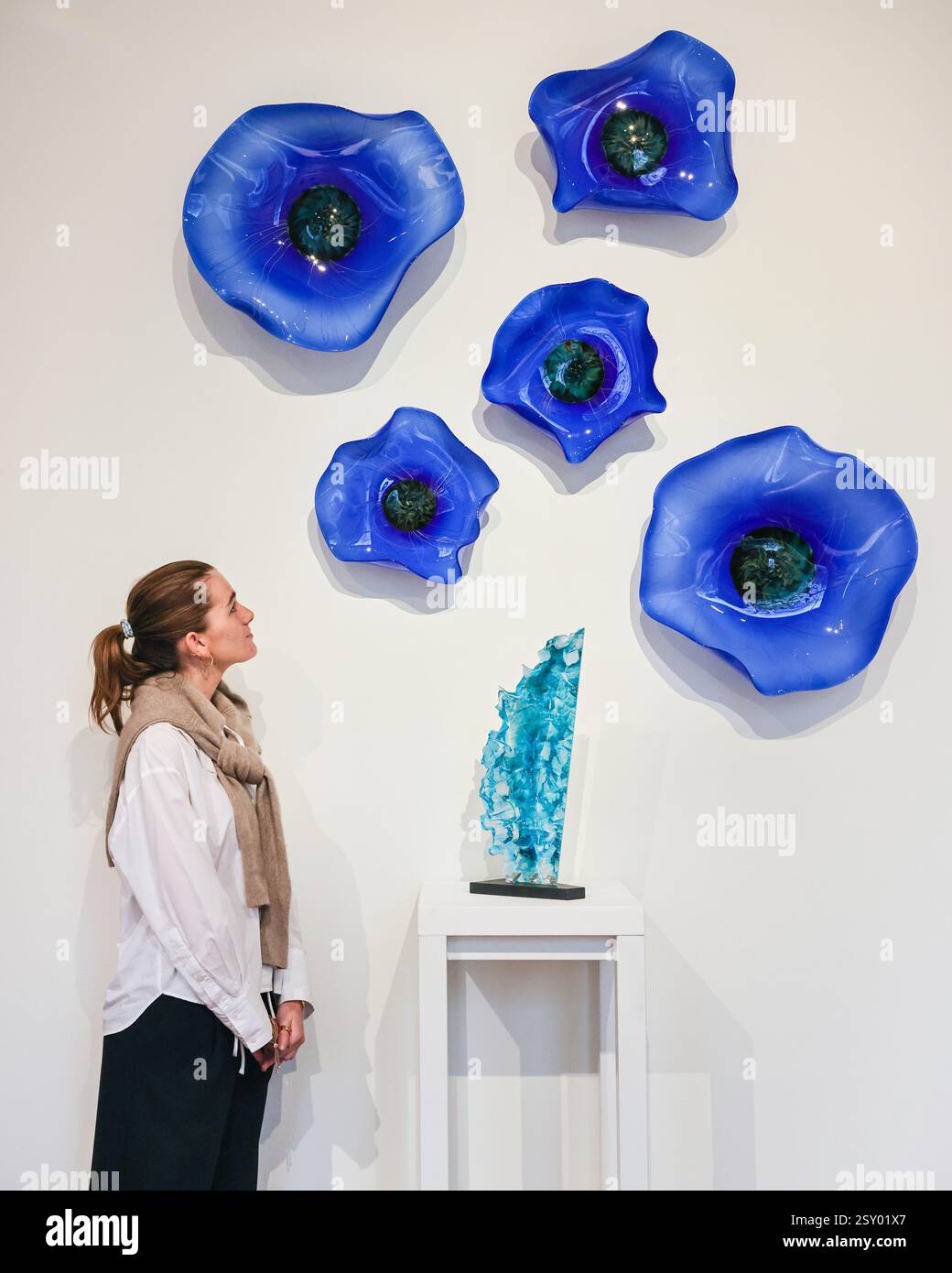 London, UK. 26th Feb 2025. Staff pose with 'Meconopsis' platters by ...