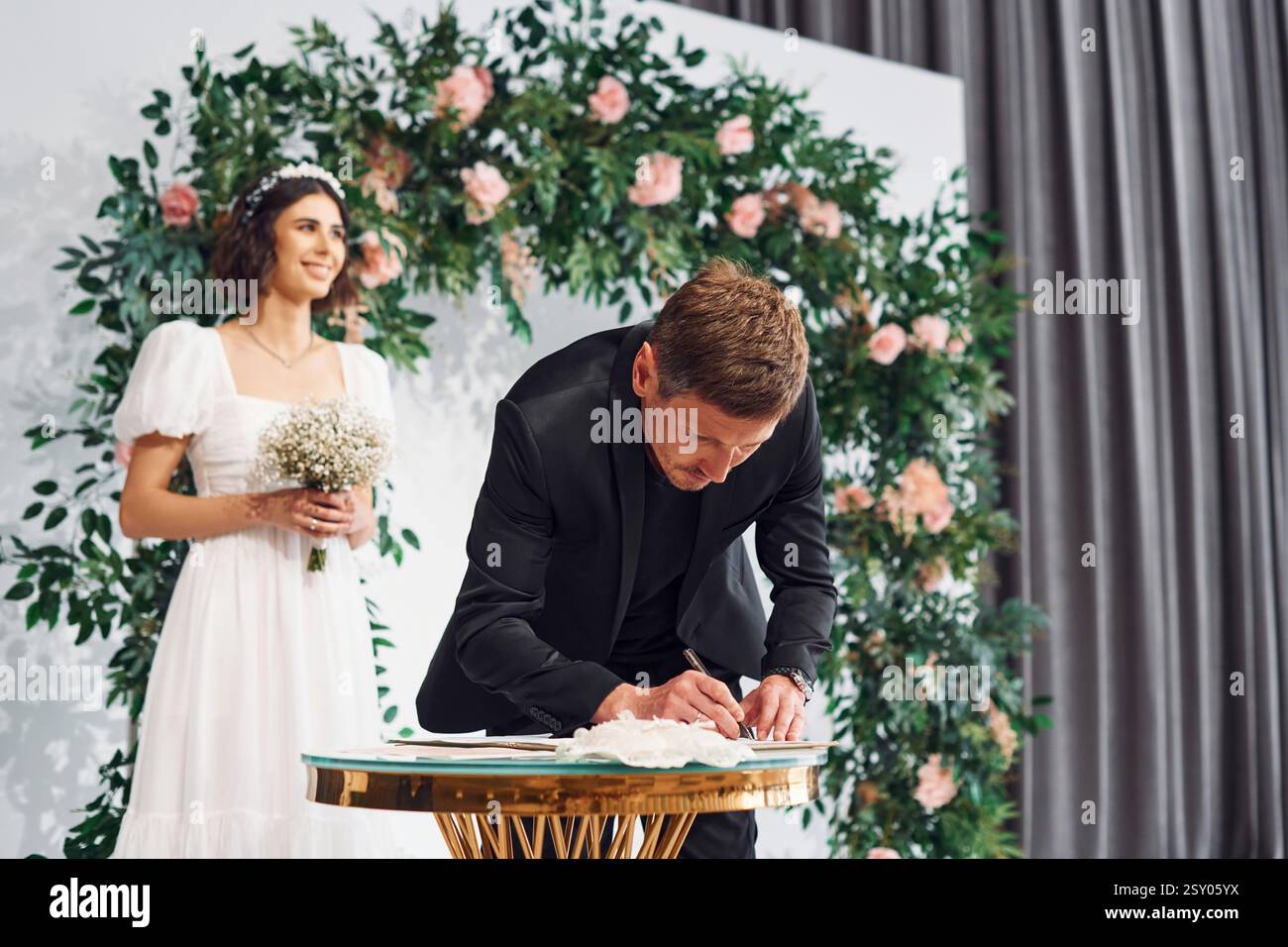 Signs the marriage document. Beautiful bride with his fiance is on the ...