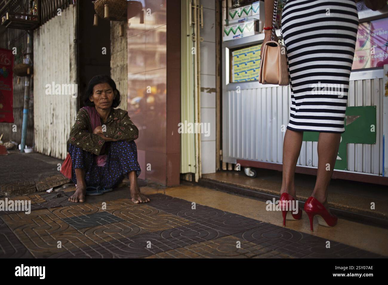 Poor woman looking at rich shoes, phnom penh, cambodia Stock Photo - Alamy