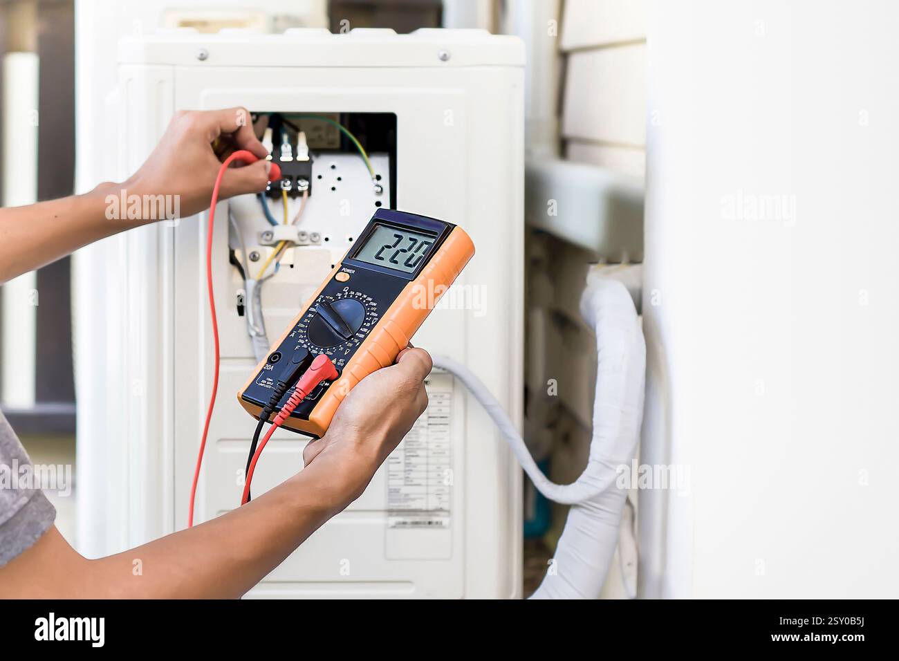 Air conditioner repairman using electricity meter to check air ...