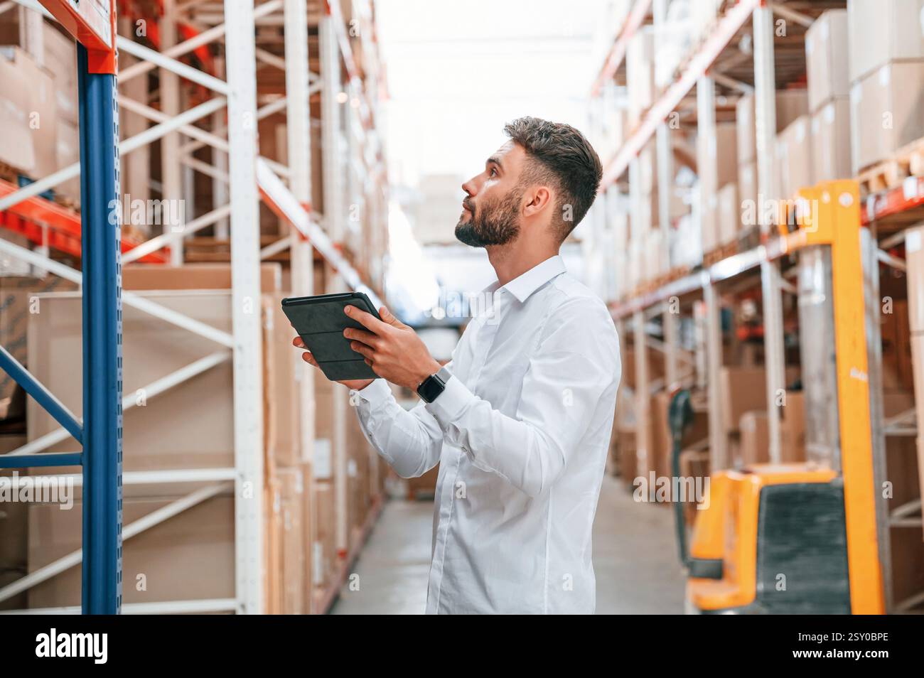 Portrait of storage worker that is in the warehouse with bunch of ...