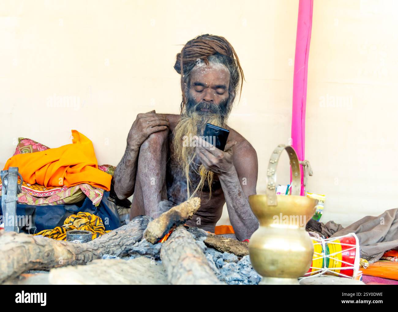 spiritual hindu naga saint watching mobile phone at mahakumbh mela ...