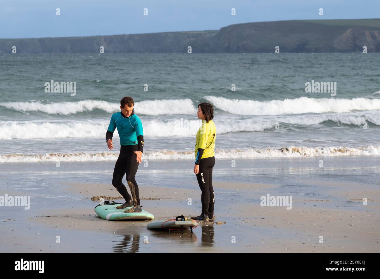 A surfing instructor from the Escape Surfing School holding a one to ...