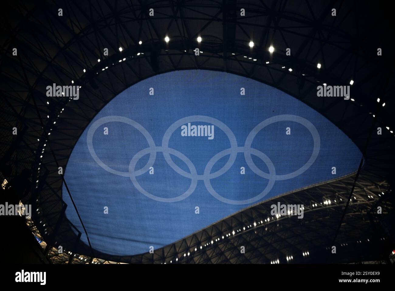 FILE - The Olympic rings are pictured through a flag hanging in the ...