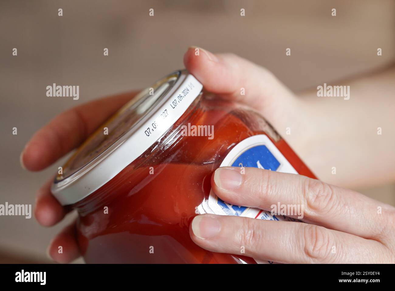 Glass jar of pickled tomatoes with white lid with expiration date ...