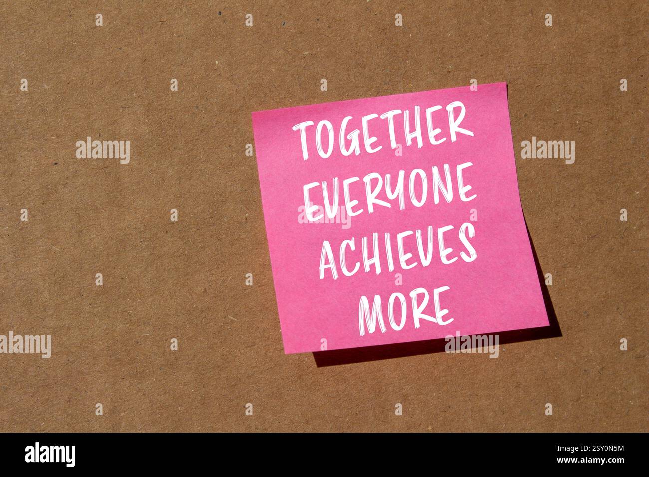 Together everyone achieves more message written on pink paper on brown ...