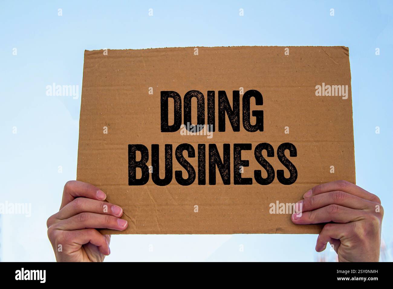 Doing business message written on cardboard sign. Conceptual doing ...