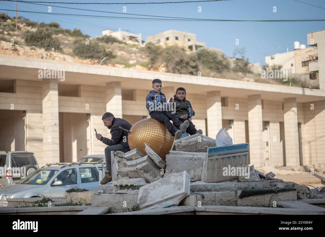 Qabatiya, Palestinian Territories. 26th Feb, 2025. Palestinian boys sit ...