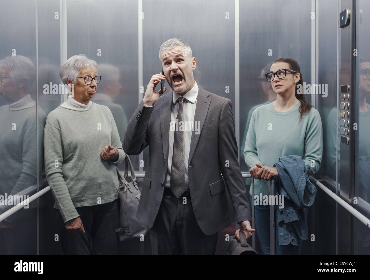 Stressed angry businessman shouting into his smartphone in the elevator ...
