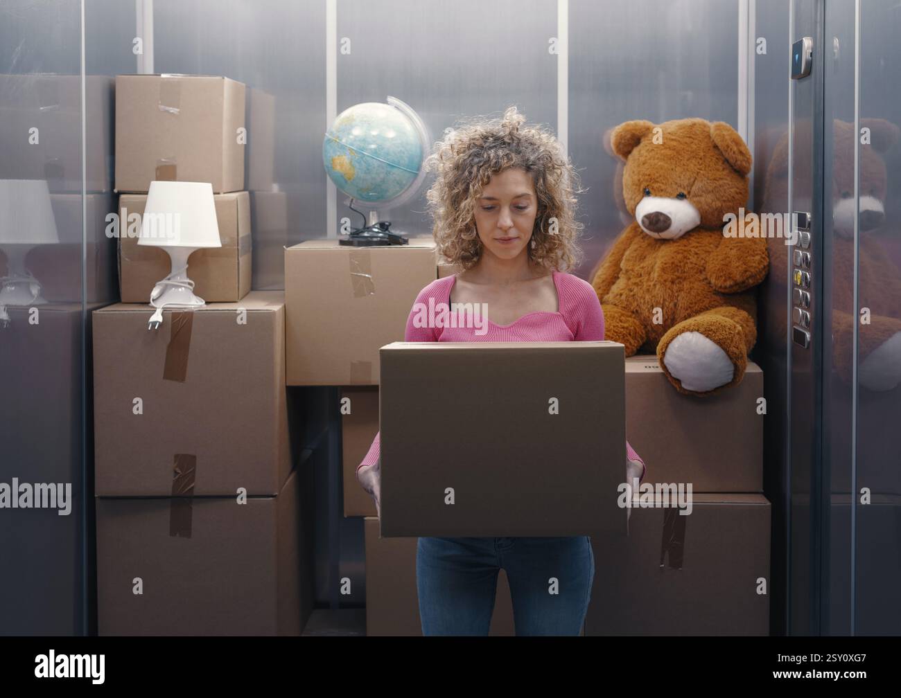 Young woman moving into her new apartment, she is standing in the ...