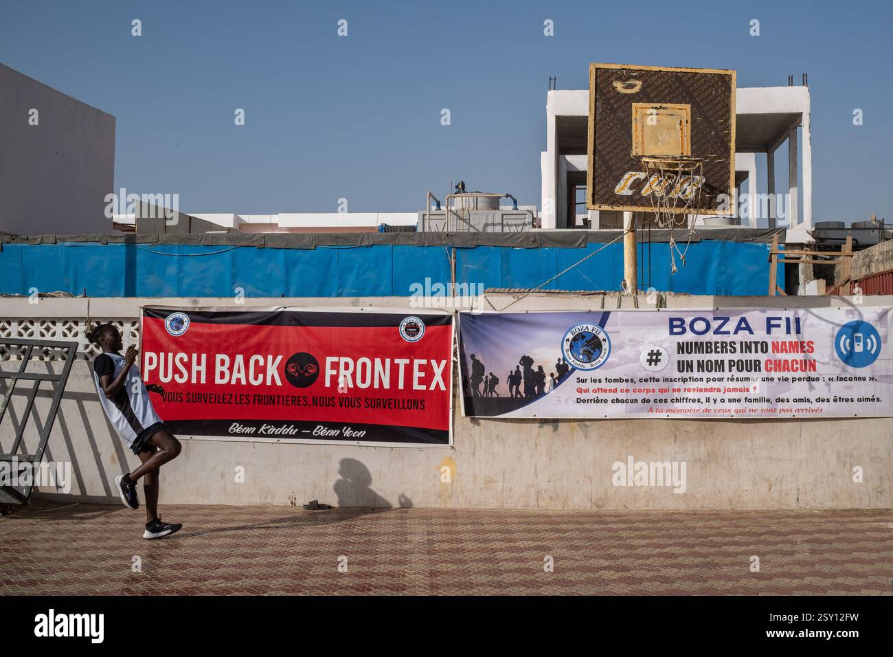 Young people play basketball on a court in Cayar, in the Thies region, on February 8, 2025 ...