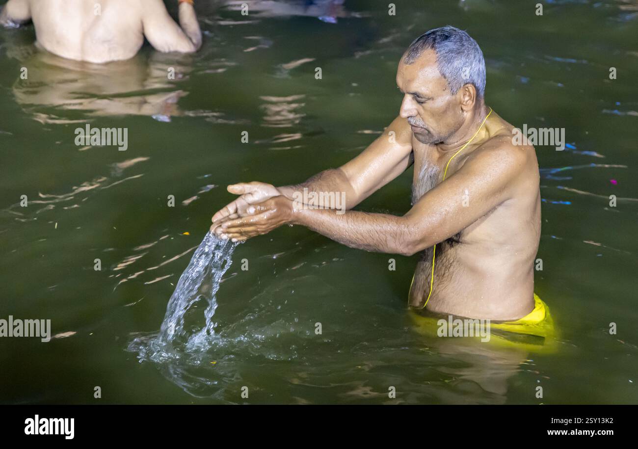 pilgrims praying after ritual bath in triveni sangam during mahakumbh ...