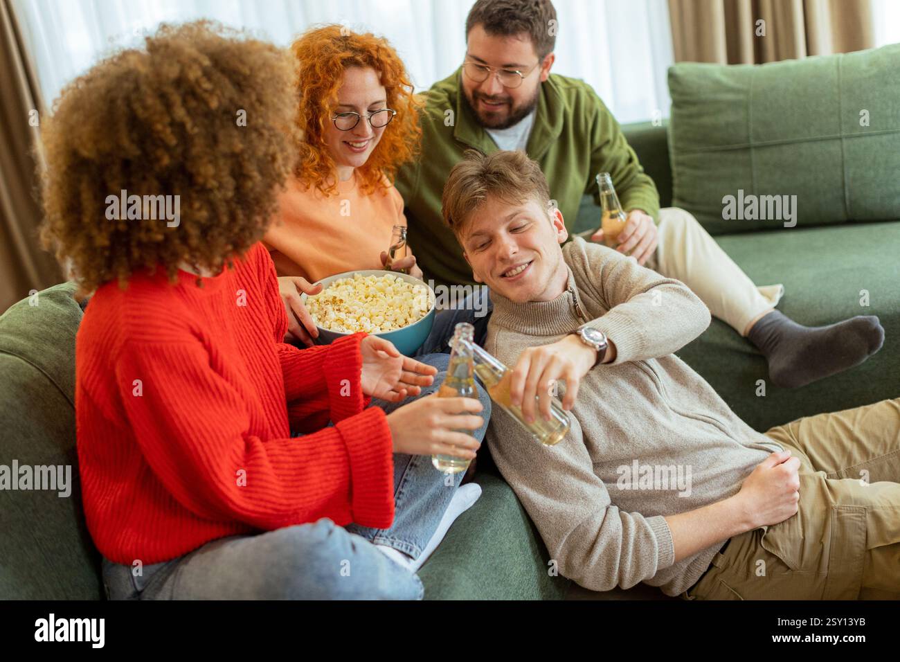 Laughter fills a well-lit living room as four friends share a joyful ...